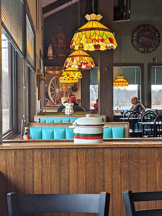 Stained glass pendant lamps cast a warm glow over turquoise booth seating. Diners don't need to be fancy to have character—this place has it in spades.