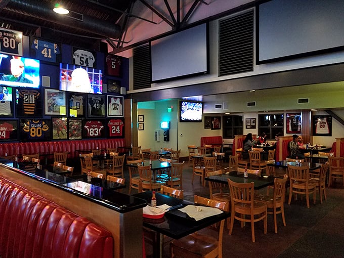 Sports memorabilia adorns walls above red booths, creating an atmosphere where food and fandom merge in a celebration of California casual dining.