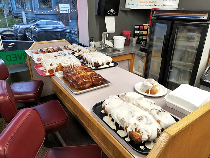 Pastry paradise awaits at the counter—cinnamon rolls and sticky buns lined up like delicious soldiers ready for their morning mission.