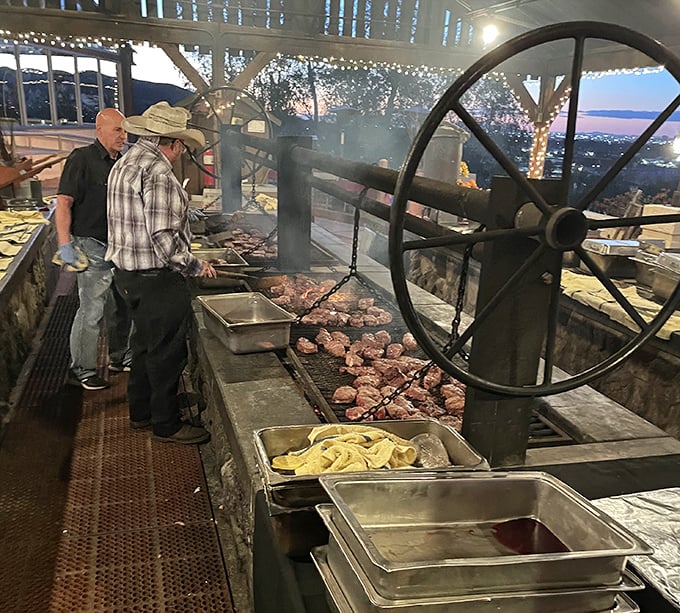 Real cowboys manning the grill with the precision of surgeons. That wheel isn't just for show—it's barbecue engineering at its finest.