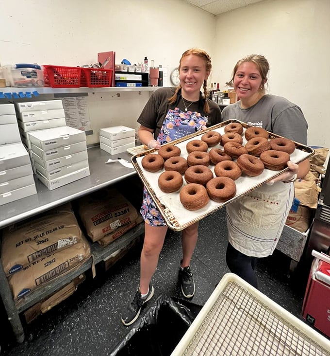 The bakers behind the magic, proudly displaying their handiwork. Those donuts didn't achieve that perfect texture by accident—they were loved into existence.