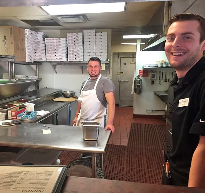 Kitchen heroes in their natural habitat – where the real magic happens behind those pizza boxes.