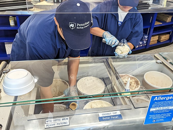 The blue-uniformed ice cream artisans at work—skilled hands creating edible joy one scoop at a time.