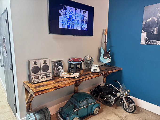 A corner that tells a story—vintage stereo equipment, model cars, and a guitar create a nostalgic vignette that adds character to the dining experience.