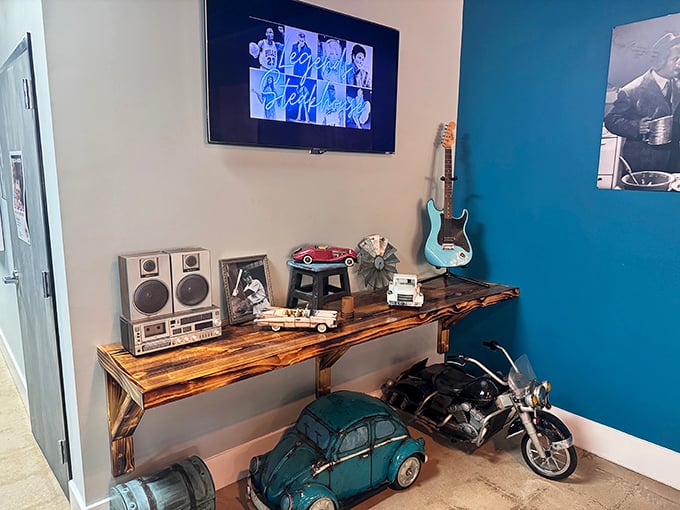 A corner that tells a story—vintage stereo equipment, model cars, and a guitar create a nostalgic vignette that adds character to the dining experience.