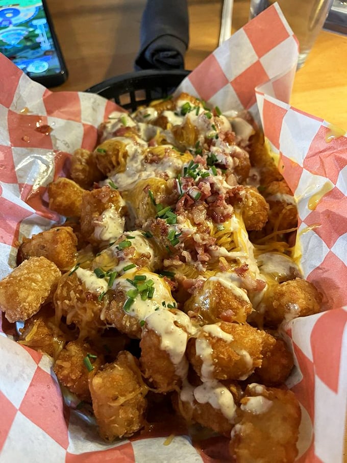 Loaded tavern tots that make French fries jealous—smothered in cheese, bacon, and chives that transform humble potatoes into a celebration on a plate.