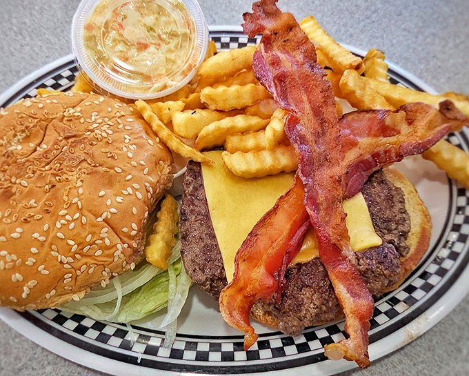 The burger that requires jaw gymnastics – stacked with bacon, cheese, and all the fixings on a perfectly toasted sesame seed bun.