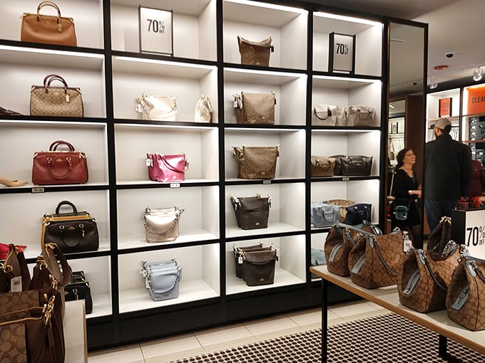 Designer handbags at 70% off—the wall of luxury that makes grown adults press their noses against the glass like kids at a candy store.
