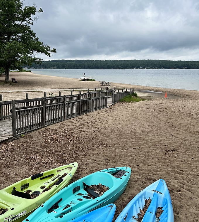 Colorful kayaks rest between adventures, like patient steeds ready to carry explorers across Otsego's blue frontier.