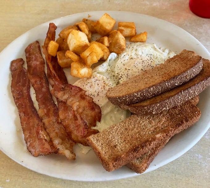 The breakfast trinity – perfectly cooked eggs, crispy bacon, and golden toast – proving that sometimes the simplest combinations are the most satisfying.