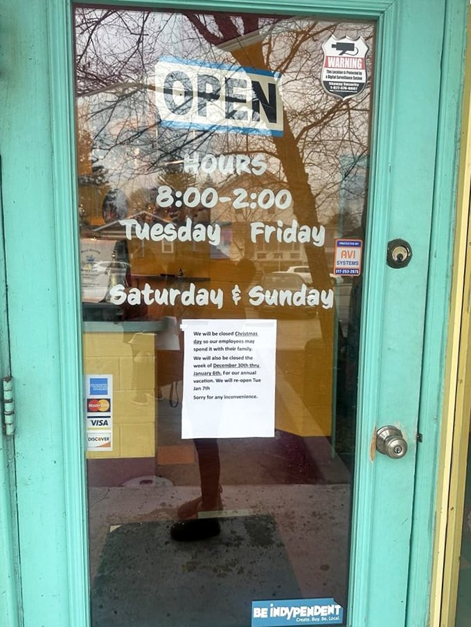 The turquoise-framed door announces operating hours like an invitation to happiness—Tuesday through Sunday, no Monday blues allowed.