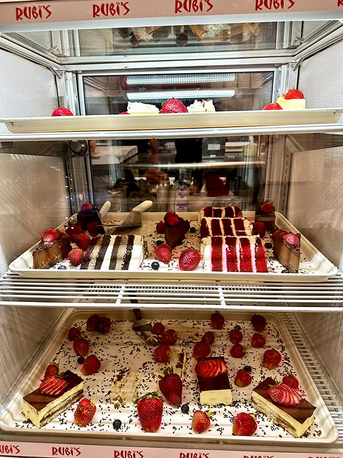 The dessert case that ruins diets and creates happiness. Those strawberry-topped treasures aren't just sweets—they're the reason pants have elastic waistbands.