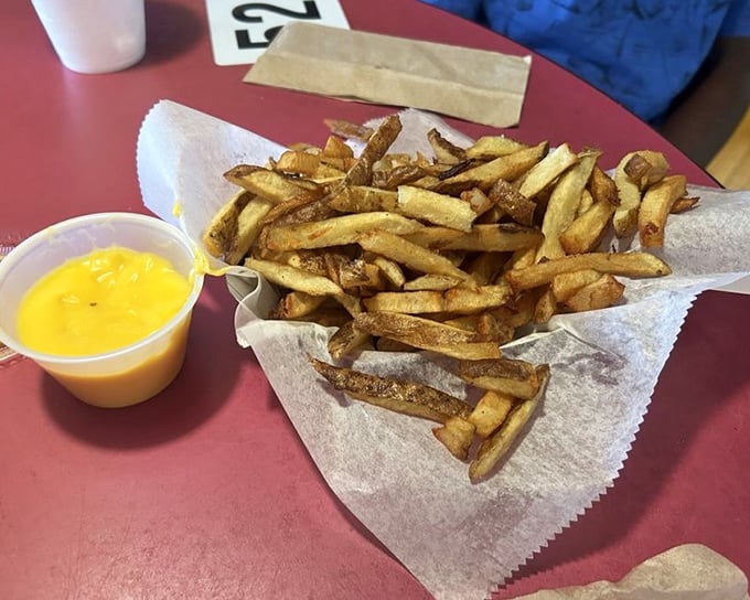 Cheese fries that make you question why potatoes would ever want to be served any other way. The cheese cup stands guard, ready for dipping duty.
