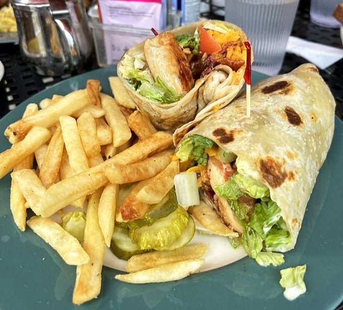 This wrap isn't just holding ingredients—it's containing a flavor explosion, served with fries that are clearly on a first-name basis with the fryer.
