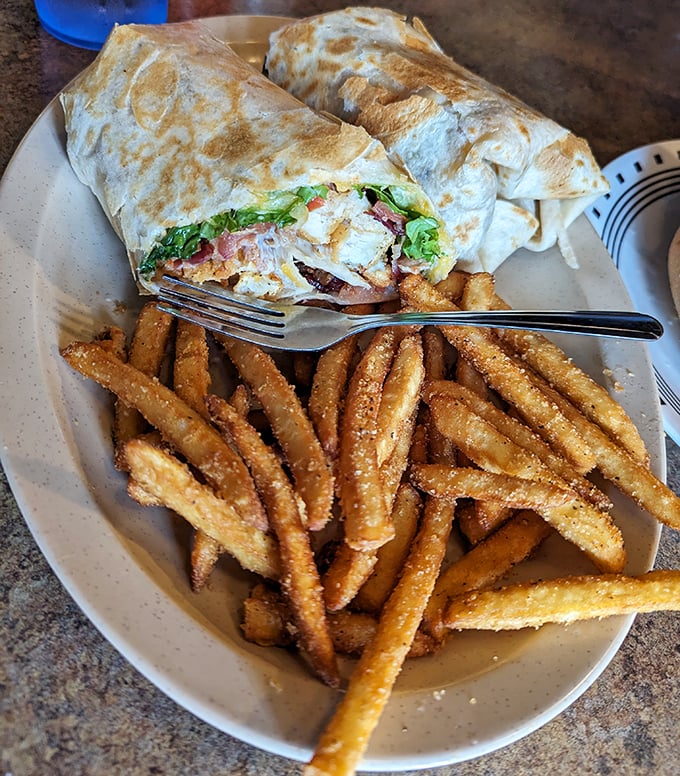 This wrap isn't messing around—packed tight with goodness and grilled to perfection. Those seasoned fries deserve their own fan club.