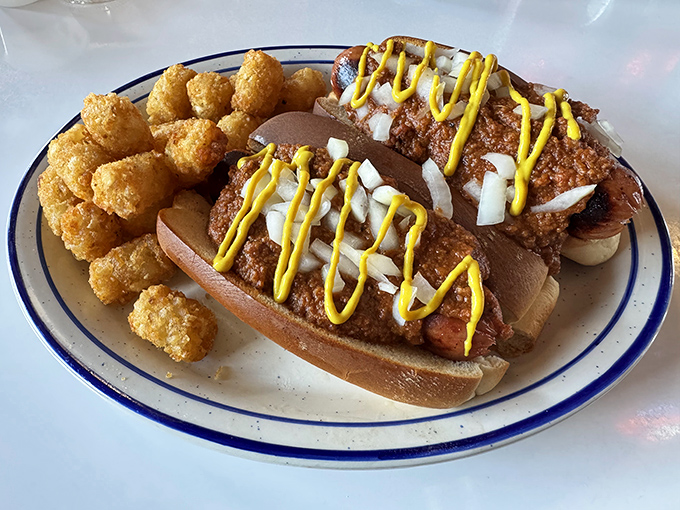 Chili dogs dressed to impress with mustard zigzags and diced onions—comfort food that doesn't need a fancy pedigree to taste magnificent.