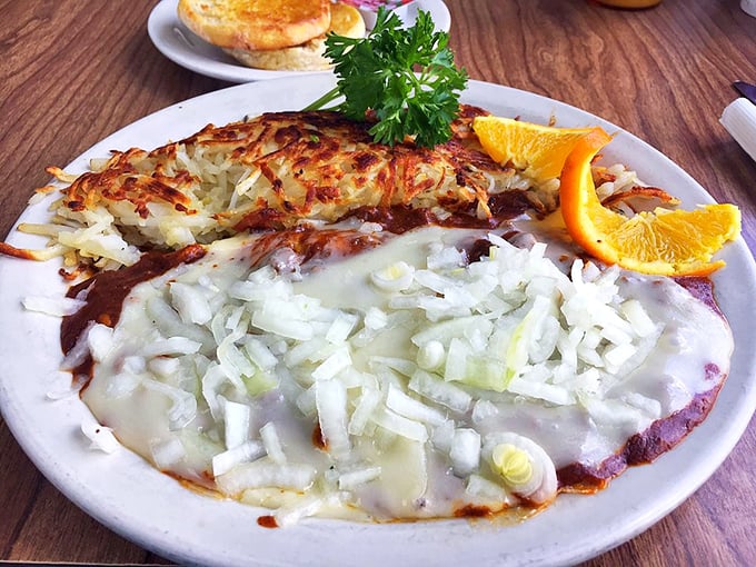 This isn't just an omelet—it's a celebration with hash browns and fresh orange slices. The crispy edges of those potatoes are what breakfast fantasies are made of.