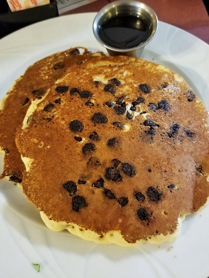This chocolate chip pancake is approximately the size of a manhole cover—and twice as satisfying. The small cup of syrup knows it's merely a suggestion.
