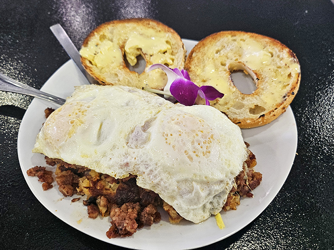 Corned beef hash topped with eggs alongside toasted bagels—a breakfast powerful enough to fuel you through any Florida adventure.