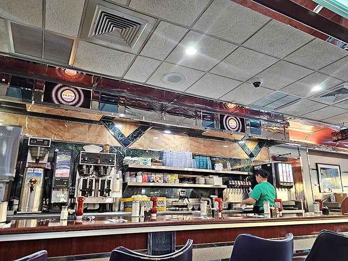 The counter—where solo diners find community, coffee achieves immortality through infinite refills, and breakfast is served with a side of banter.