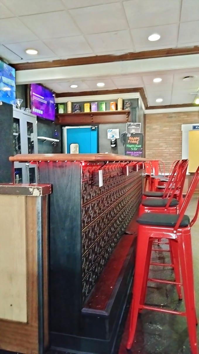 Bright red bar stools pop against dark wood, offering front-row seats to the barbecue show that unfolds behind the counter.