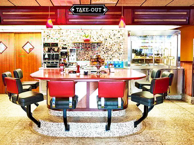 The counter island with its distinctive curved design – a diner's social hub where regulars claim their territory and newcomers become converts.