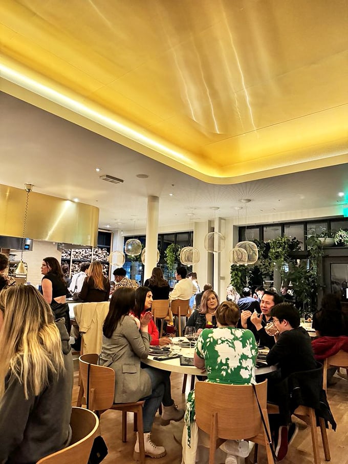 Happiness looks like this: a dining room filled with people experiencing the joy of discovery. The golden ceiling reflects the warm conversation below.