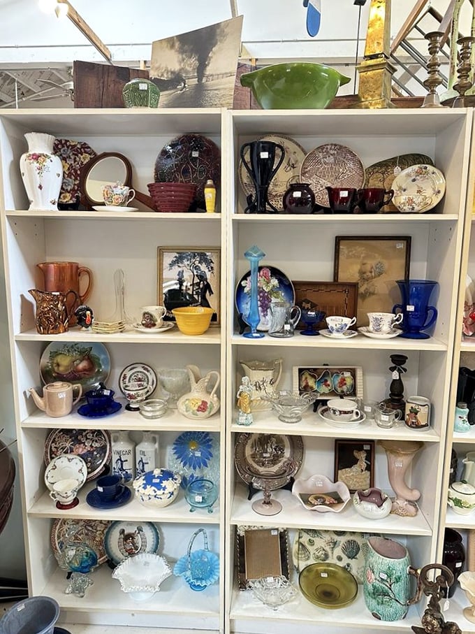 Shelves of vintage dishware tell stories of dinner parties past, where floral patterns and cobalt blue pieces wait to grace new tables.
