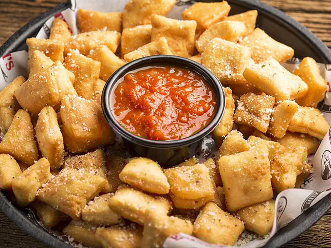 Dough nuggets dusted with Parmesan await their marinara bath—the appetizer that's secretly everyone's favorite part of the meal.