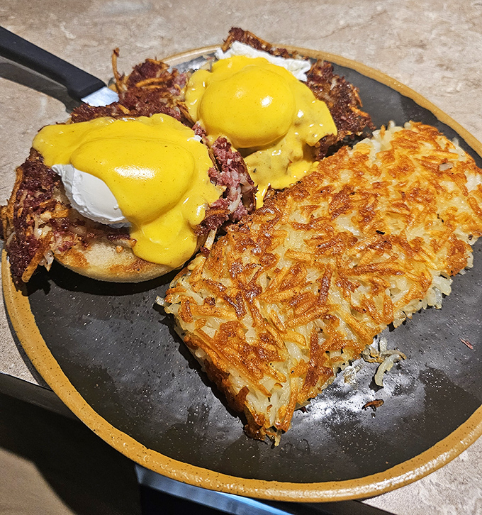 Eggs Benedict reimagined: poached eggs perched atop corned beef hash instead of English muffins—a breakfast rebellion worth joining.