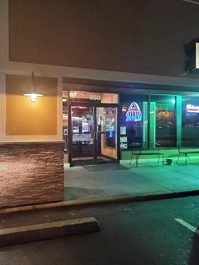 As evening falls, the neon glow beckons hungry travelers like a lighthouse guiding ships to safe harbor—except this harbor serves pork tenderloin.