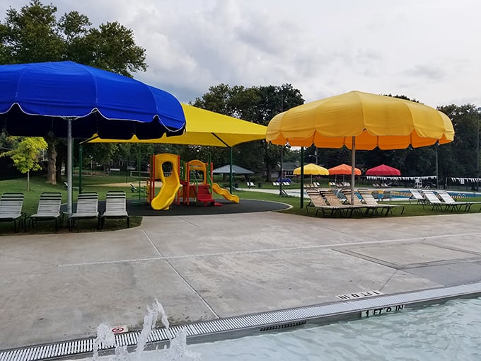 The community pool's cheerful umbrellas stand ready for families seeking refuge from Pennsylvania summer heat that can rival the tropics.