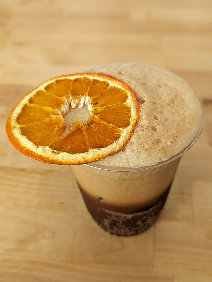 The espresso tonic—where bitter meets sweet in a refreshing citrus-topped concoction that redefines coffee refreshment.
