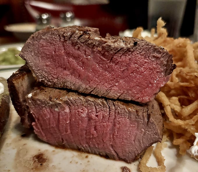 The cross-section of a perfectly cooked filet tells you everything you need to know about this place – they understand the sacred relationship between fire and beef.