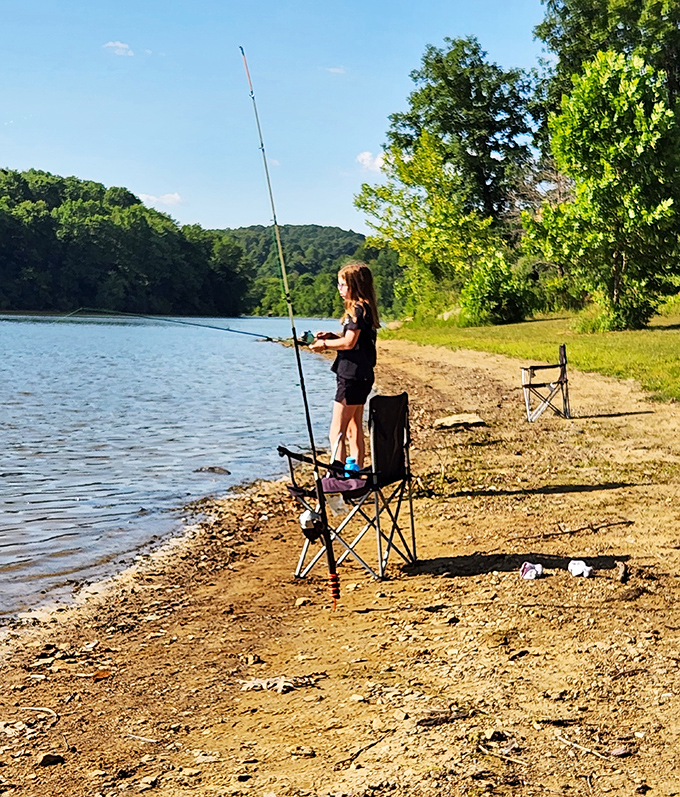 Patience personified: A young angler demonstrates the timeless art of fishing—equal parts skill, hope, and comfortable folding chairs.