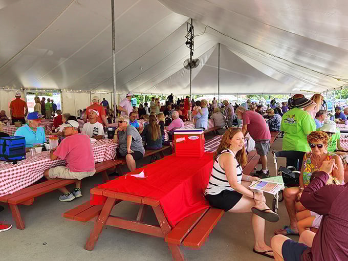 The social heart of bargain hunting! Red picnic tables under a white tent create the perfect setting for debating the merits of your morning finds.