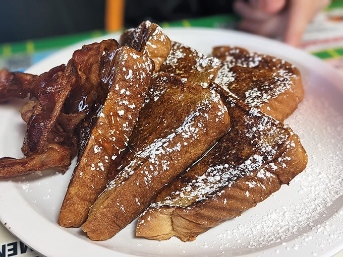 French toast that's achieved golden perfection – crispy edges, custardy centers, and a dusting of powdered sugar that sparkles like morning frost.
