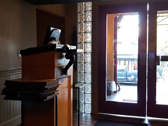 The entrance speaks of transitions—from the everyday world outside to the temple of gastronomy that awaits beyond those wooden doors.