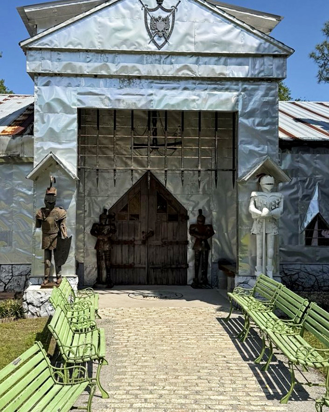 Green benches line the path to the castle entrance, where metal knights stand ready to welcome modern-day visitors to their recycled realm.