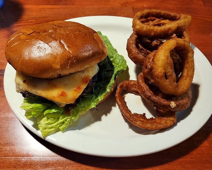 A burger that demands a two-handed commitment, paired with onion rings that achieve that mythical balance between crispy coating and tender onion.