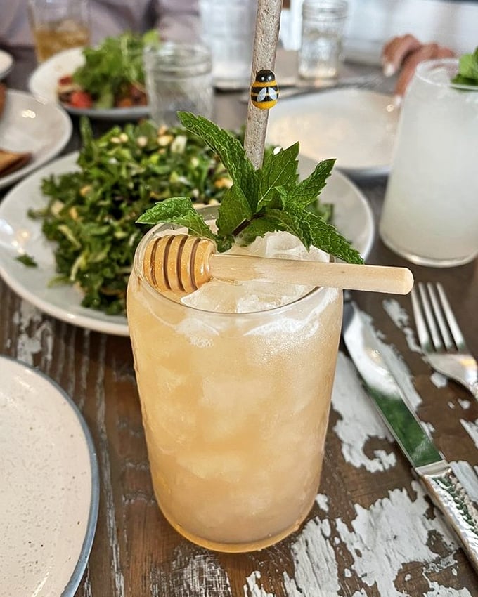 This honey-infused cocktail, garnished with fresh mint and a honey dipper, isn't just a drink—it's liquid sunshine in a glass.