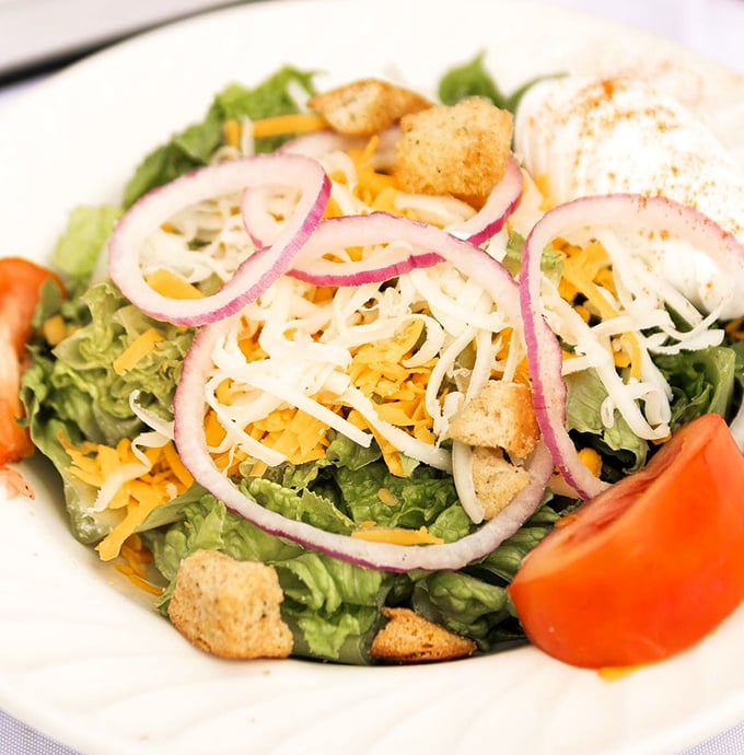 A house salad that doesn't apologize for being healthy—bright, crisp, and colorful with just enough cheese to remind you that pleasure matters too.