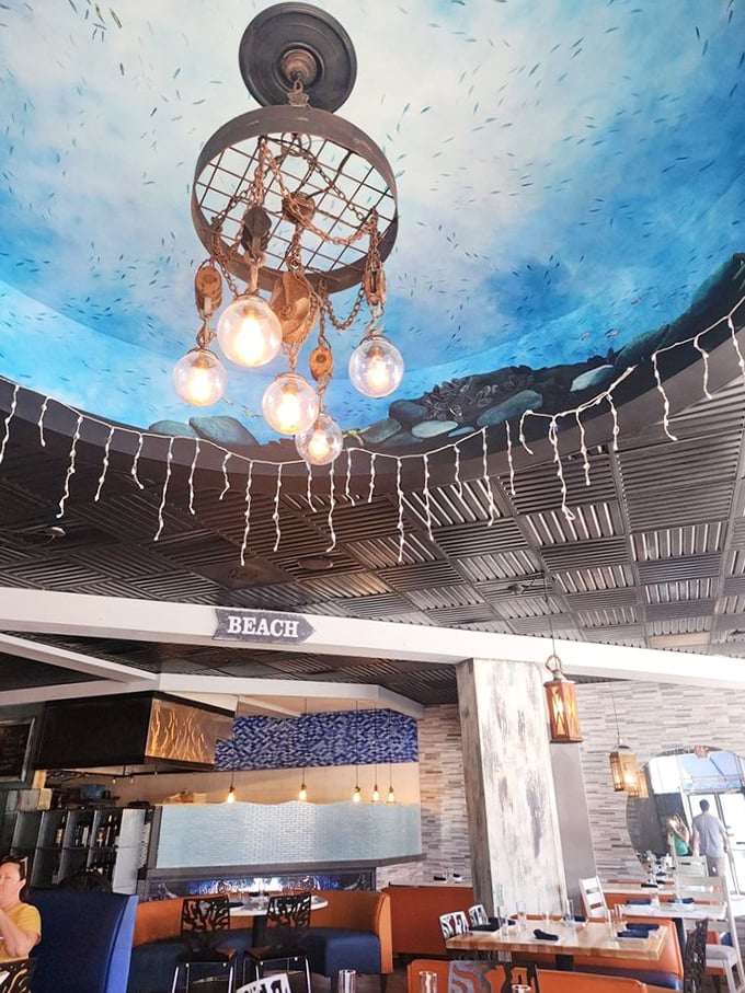 Look up and you're underwater – that ceiling with its ocean-blue paint and fishing net chandelier is nautical whimsy at its finest.
