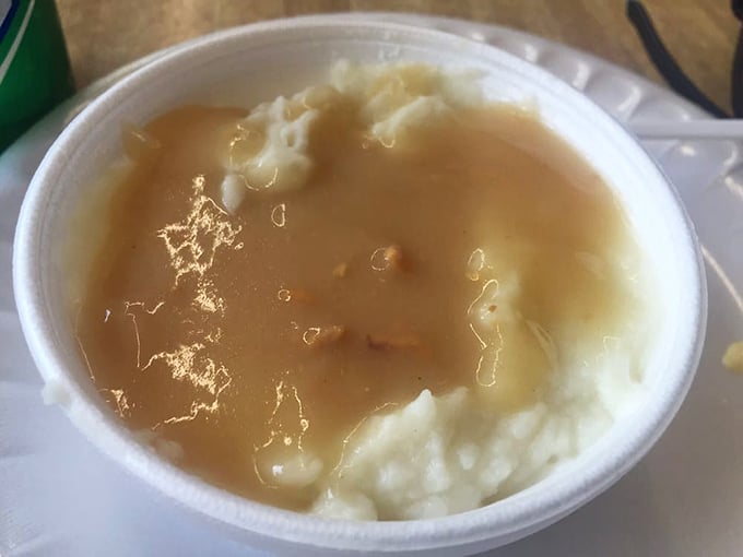 Mashed potatoes and gravy that remind you why comfort food earned its name – a warm, savory hug in a humble takeout container.