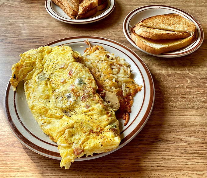 This omelet didn't just happen—it was engineered for maximum satisfaction. Paired with crispy hash browns and toast, it's breakfast perfection.