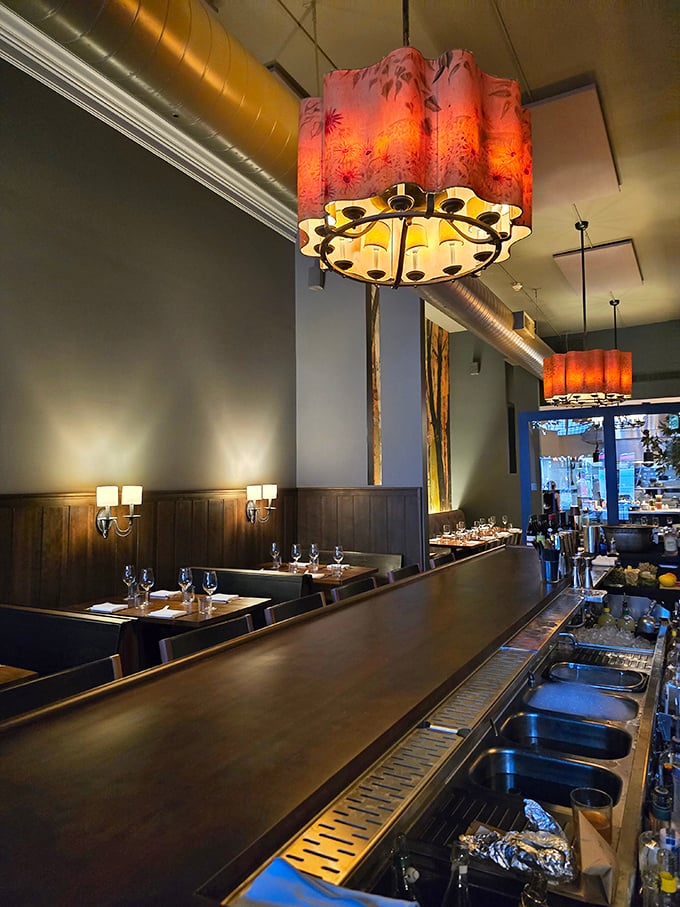 Industrial meets intimate with these pendant lights casting a warm glow over cozy booths. The wood paneling whispers, "Stay awhile, order dessert."