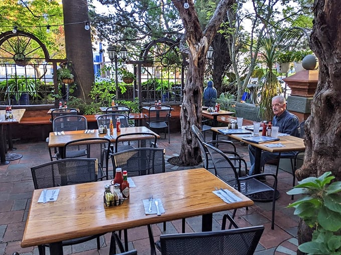 The garden patio offers dappled shade and natural beauty—an urban oasis where trees grow through the dining space and Sacramento's weather shines.
