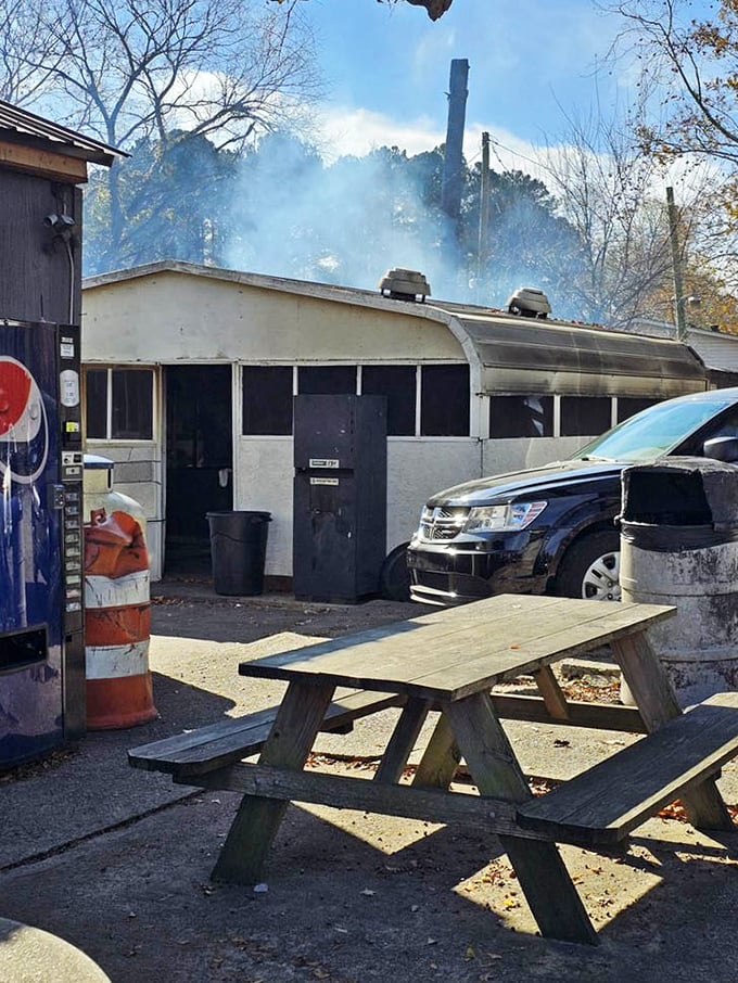 Smoke billows from the pit house behind B's—the barbecue equivalent of seeing the Bat Signal. Heroes work here, armed with wood and patience.