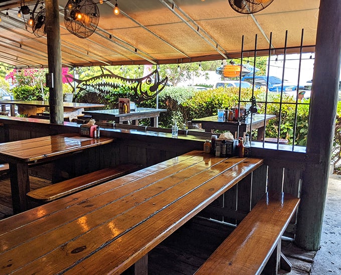 Wooden picnic tables under a simple canopy—where conversations flow as easily as the beer and seafood arrives with zero fanfare but maximum flavor.