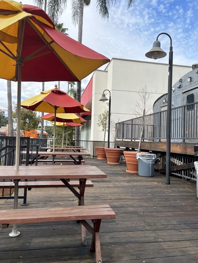 The outdoor seating area offers a perfect California dining experience: wooden picnic tables, cheerful umbrellas, and the gentle reminder that al fresco eating is a birthright here.